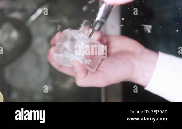 Split ice cube. Beverage preparation. Male bartender hands with large ...