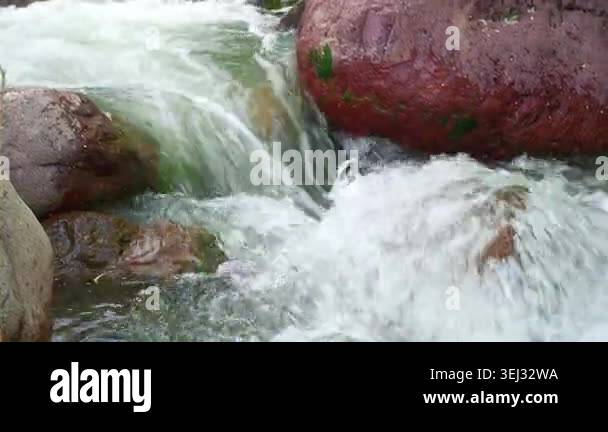 Close up of fast mountain river stream flowing between large rocks ...