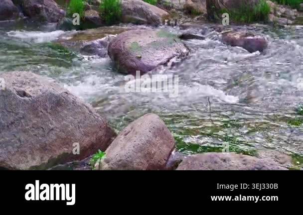 Static view of stormy mountain river current rushing between rocks and ...