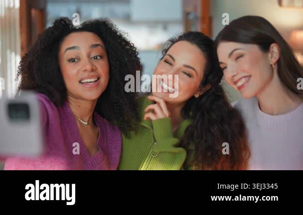 Cute ladies taking selfie mobile phone sitting apartment couch together ...