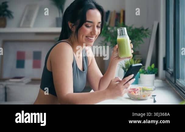 Video of fitness woman drinking a healthy green juice while using ...