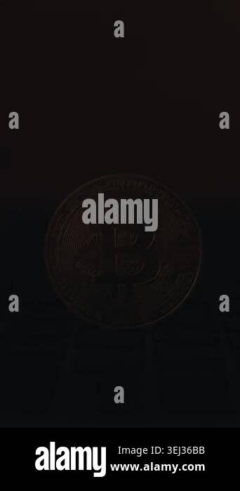 Bitcoin cryptocurrency coin on laptop keyboard with warm neon lighting ...