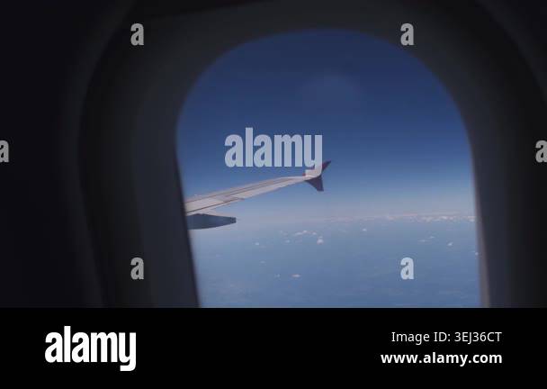 Airplane window. View of sky from inside of airplane. Airplane wing and ...