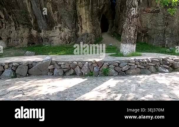 Beautiful cinematic tilt-up shot of mysterious cave entrance in massive ...