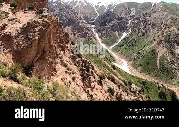 Cinematic tilt-up panning shot of the Chimgan Mountains in Uzbekistan ...