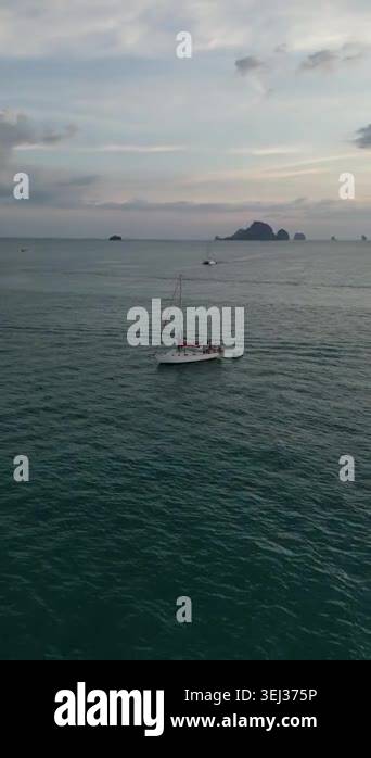 Aerial perspective showing a sailboat navigating the calm ocean waters ...