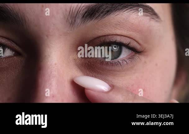 4K video macro closeup of young woman gently pinching under eye area ...