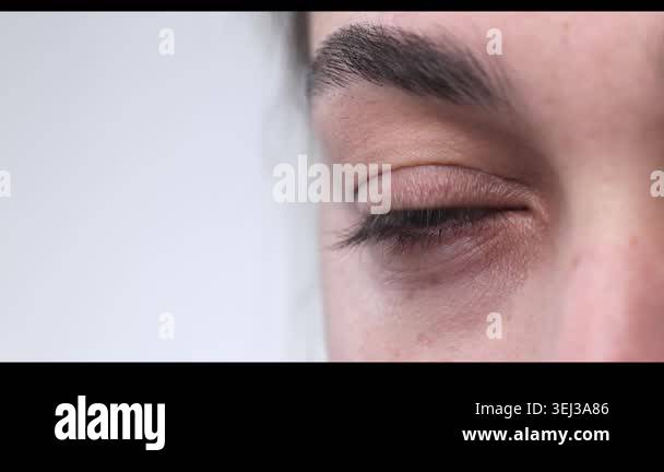 4K video macro side view closeup of young woman eye closing and ...
