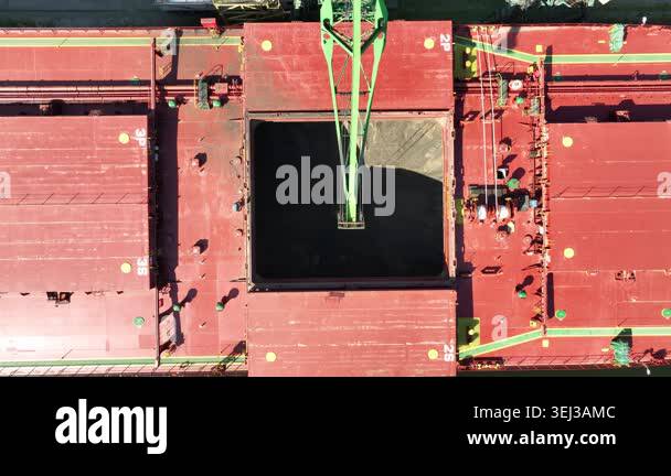 Unloading dry cargo ship of wheat by cranes in port. Aerial view ...