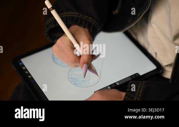 Close up of a hand holding a white stylus while drawing a circular blue ...
