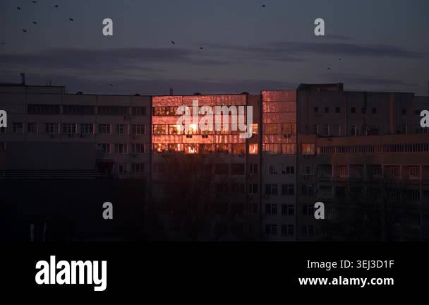 Cinematic shot of city buildings reflecting warm sunset light while ...