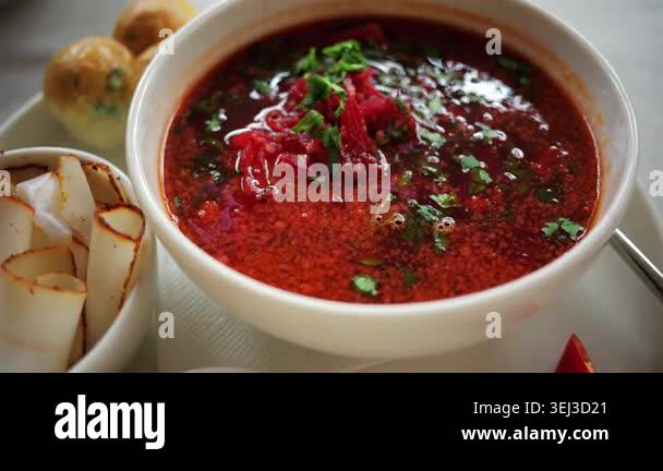 Top down view of a bowl of traditional beetroot soup, garnished with ...