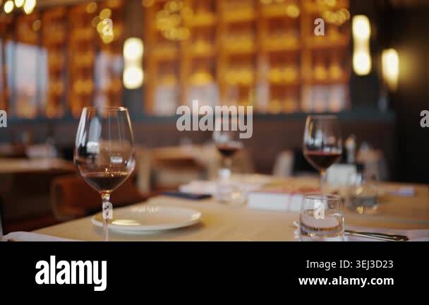 Elegant restaurant table setup with multiple wine glasses, plates, and ...