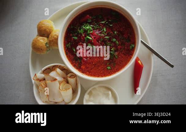 Top down view of a bowl of traditional beetroot soup, garnished with ...