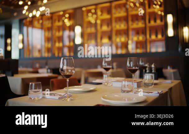 Elegant restaurant table setup with multiple wine glasses, plates, and ...