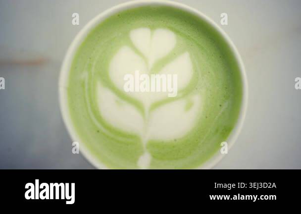 Top down view of a green matcha latte with detailed leaf shaped latte ...