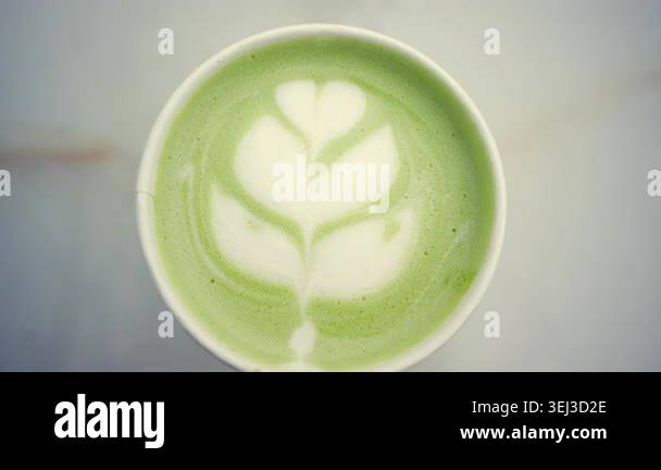 Top down view of a green matcha latte with detailed leaf shaped latte ...