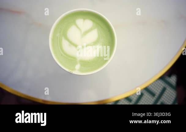 Top down view of a green matcha latte with detailed leaf shaped latte ...