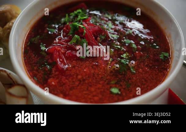 Top down view of a bowl of traditional beetroot soup, garnished with ...
