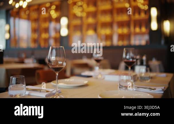 Elegant restaurant table setup with multiple wine glasses, plates, and ...