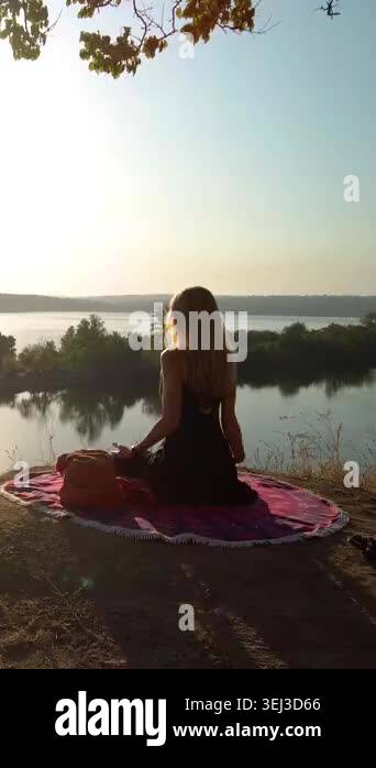 Young woman meditating on lake shore during beautiful sunrise Woman ...