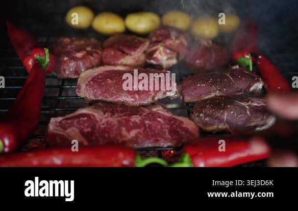 Grilled meat with visible sear marks being turned while cooking over ...