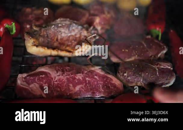 Grilled meat with visible sear marks being turned while cooking over ...