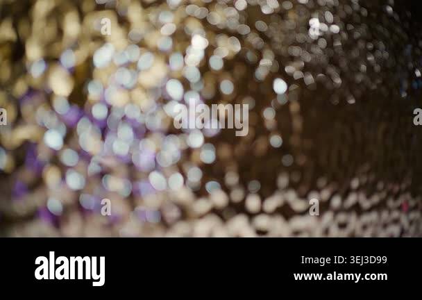 Abstract close up of golden, white, and purple bokeh lights with a soft ...