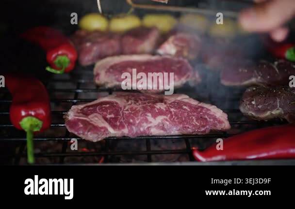 Grilled meat with visible sear marks being turned while cooking over ...