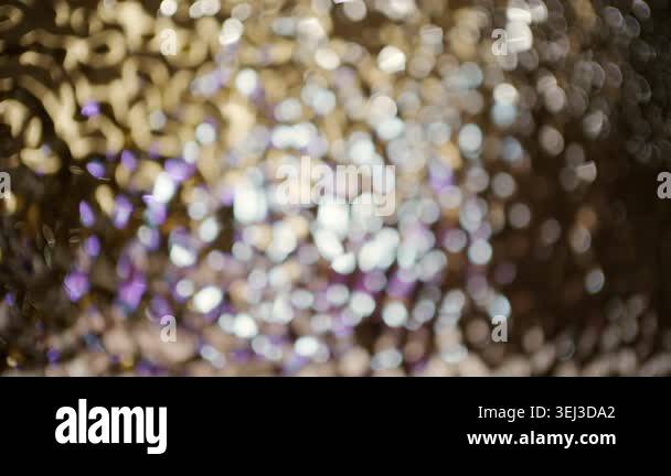 Abstract close up of golden, white, and purple bokeh lights with a soft ...
