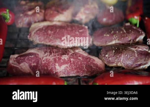 Grilled meat with visible sear marks being turned while cooking over ...