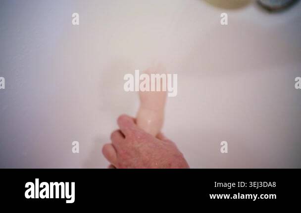 Close up of newborn baby being gently bathed by caregiver during bath ...