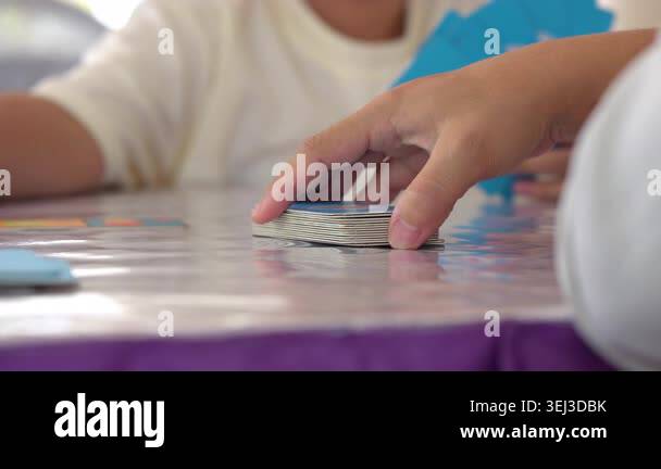 Focused little girl holding and looking at blue domino pieces while ...