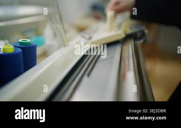 Close up of a knitting machine with metal needles, numbered measuring ...