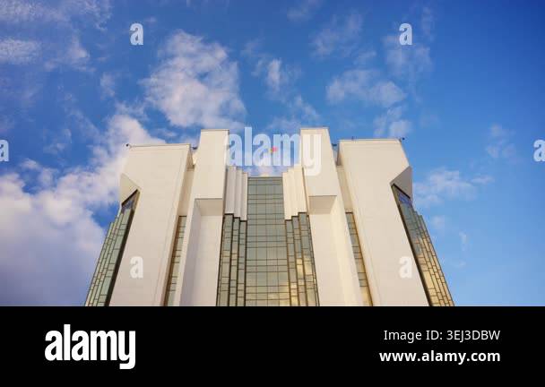 Low angle exterior view of a tall white modernist building with strong ...