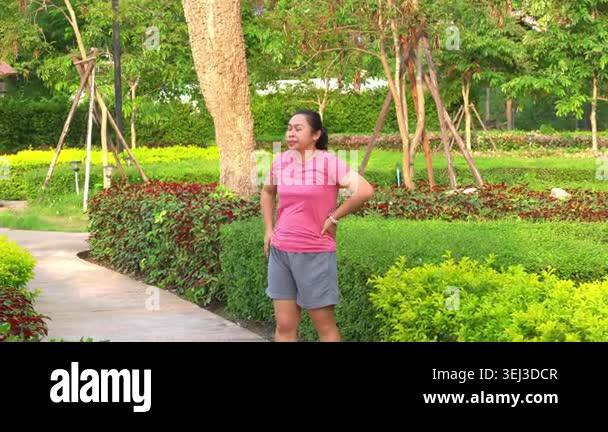 Tired Asian woman standing and resting after jogging and workout in the ...