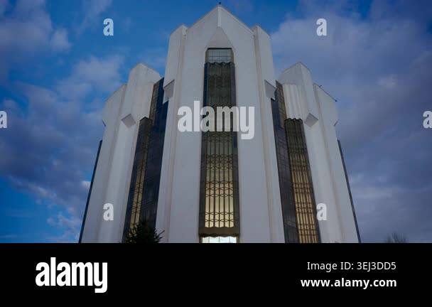Low angle exterior view of a tall white modernist building with strong ...