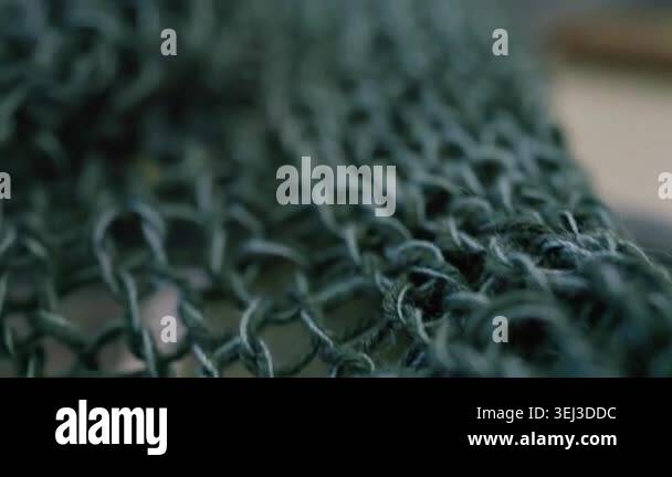 Close up of dark green knitted fabric with large textured loops and ...