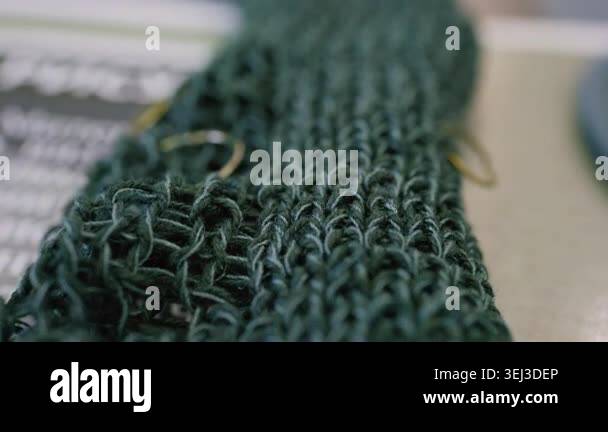 Close up of dark green knitted fabric with large textured loops and ...