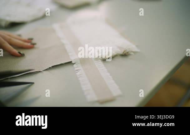 Close up of layered white and beige textile samples with frayed edges ...