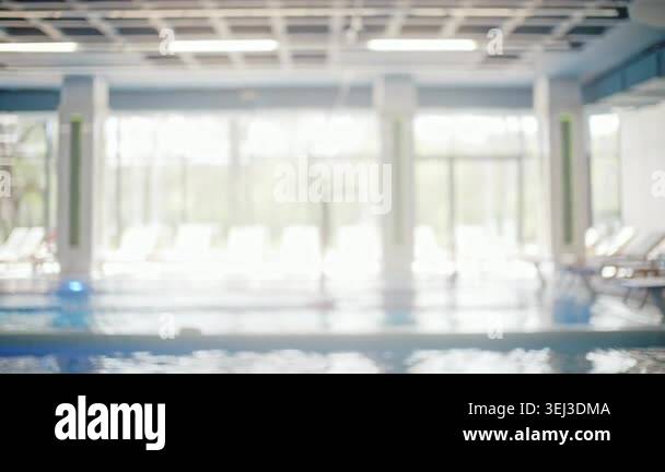 Blurred view of people training in an inside swimming pool with ...