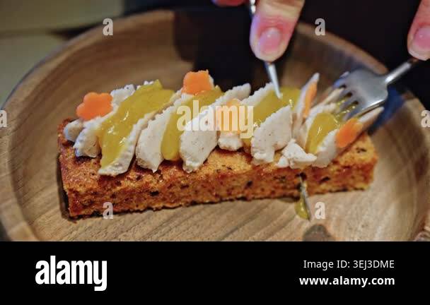 Close up of a slice of moist carrot cake topped with cream cheese ...