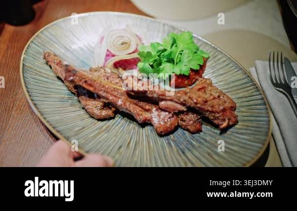 A plated dish of grilled meat served on a decorative plate, the dish is ...