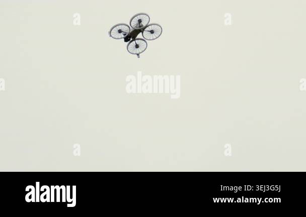A drone flying high in a clear sky, captured from below with a ...