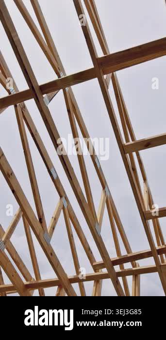 Wooden beams form complex structure for building roof as workers ...