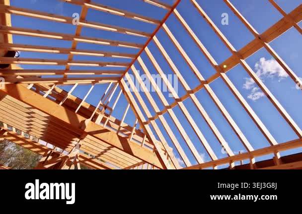Workers build wooden roof frame with beams trusses as roofing framing ...