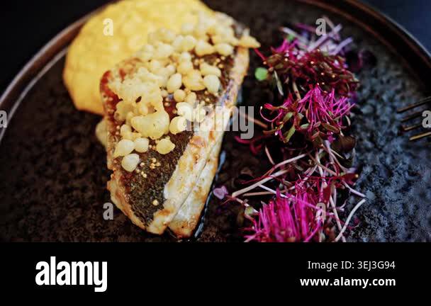 Close up of a pan seared white fish fillet with crispy skin, topped ...