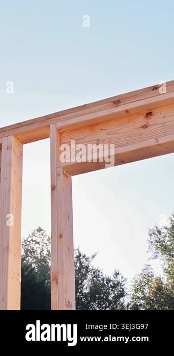 Construction workers are putting up wooden beams frame for new building ...
