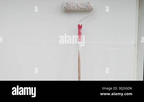 Paint roller applying white paint on a wall Stock Video Footage - Alamy