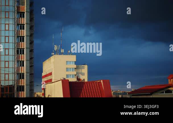 Urban buildings under dark dramatic clouds with strong contrast ...